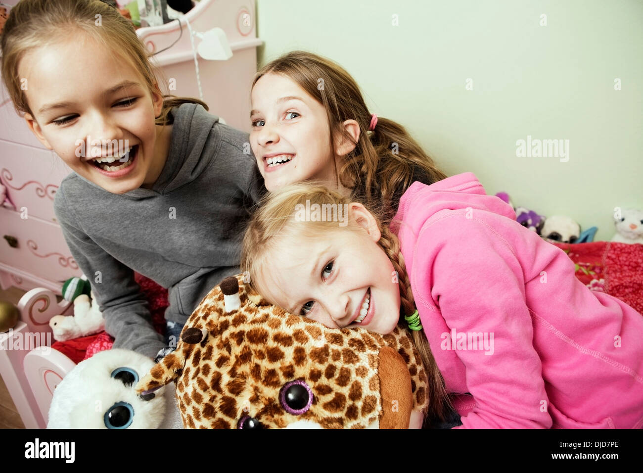 Three playful girls on bed Stock Photo - Alamy