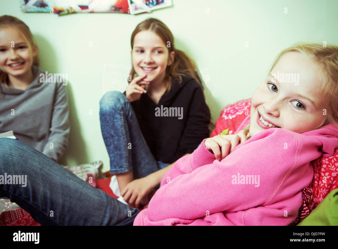 Three smiling girls on bed Stock Photo - Alamy