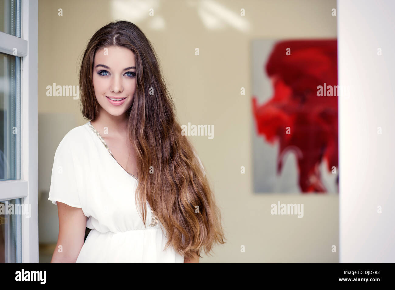 Smiling teenage girl looking out of window Stock Photo - Alamy