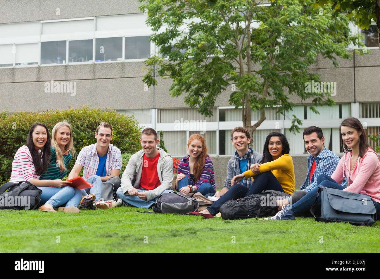 Group of students smiling at camera on the grass on campus Stock Photo ...