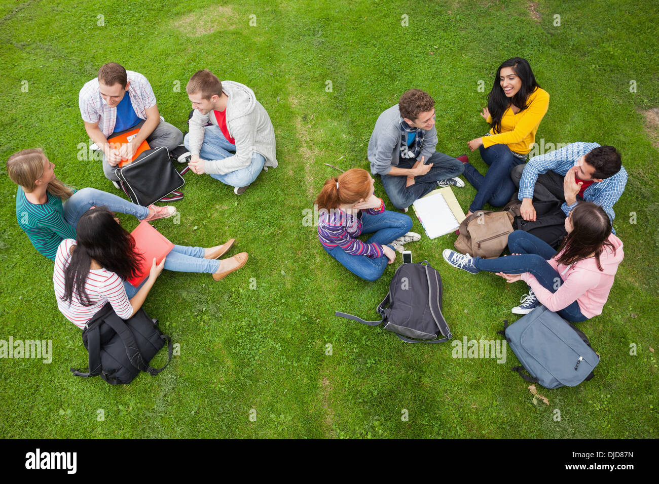 Group of students chatting together on the grass on campus Stock Photo ...