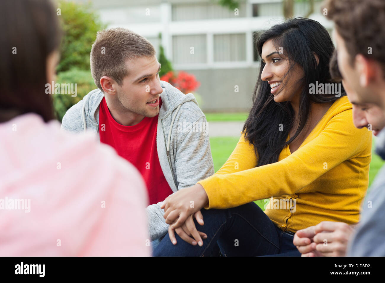 Cheerful young students taking a break outside on campus Stock Photo ...