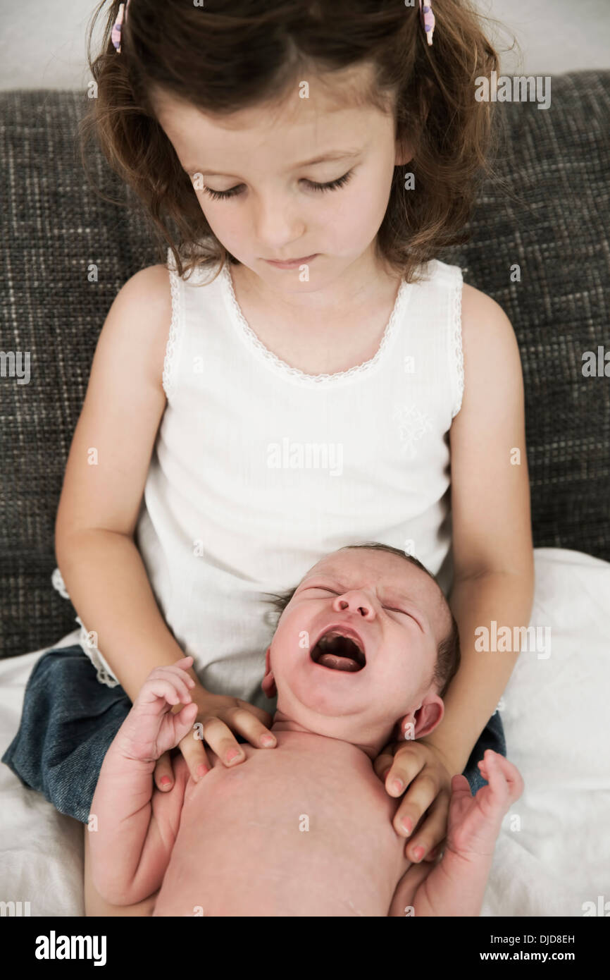 Little girl and her crying newborn brother at home Stock Photo - Alamy