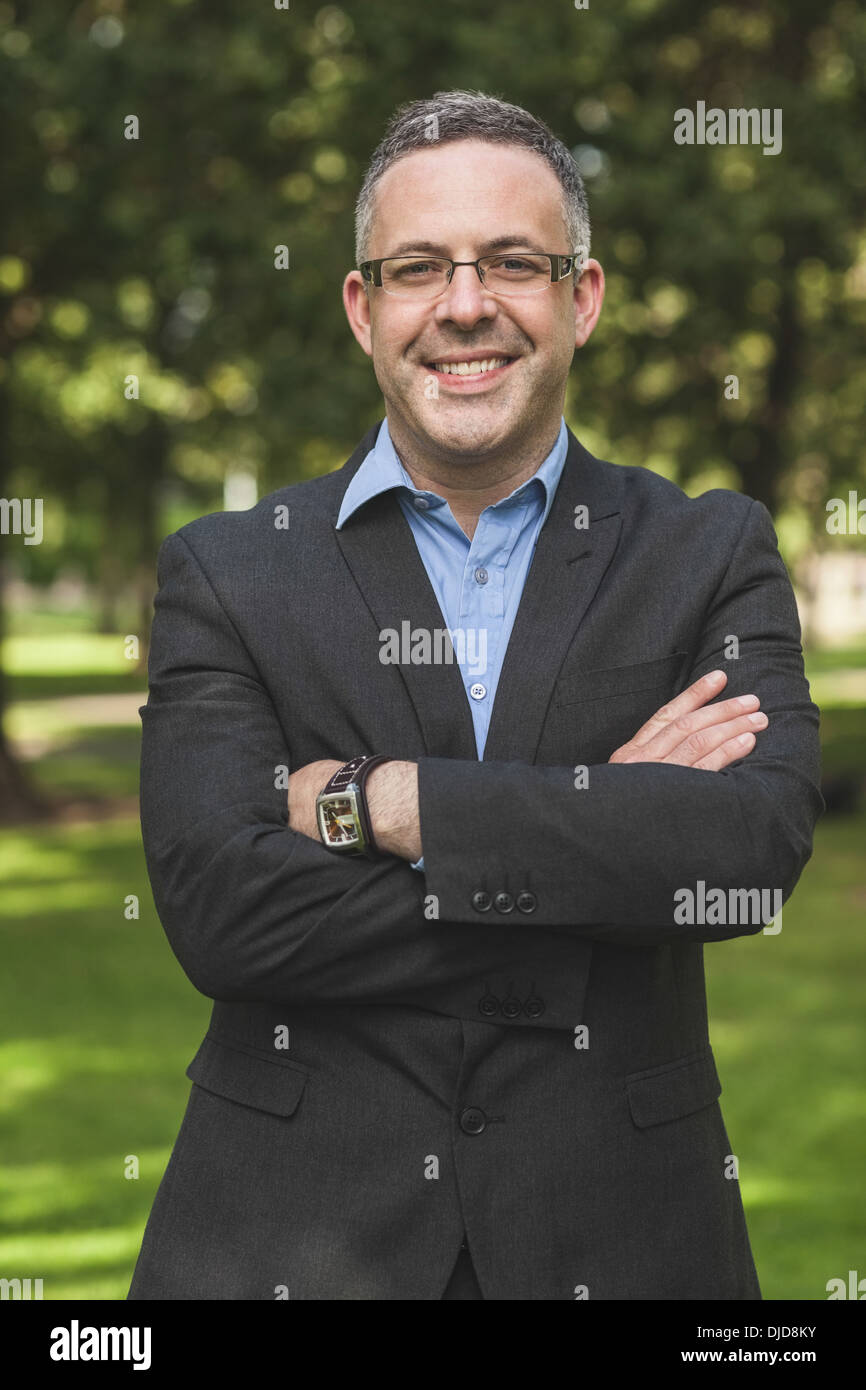 Happy professor looking at camera with arms crossed on campus Stock ...
