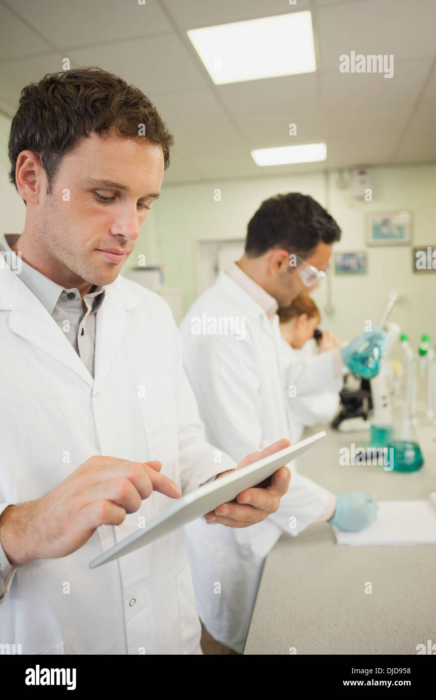 Cute young scientist using his tablet Stock Photo - Alamy