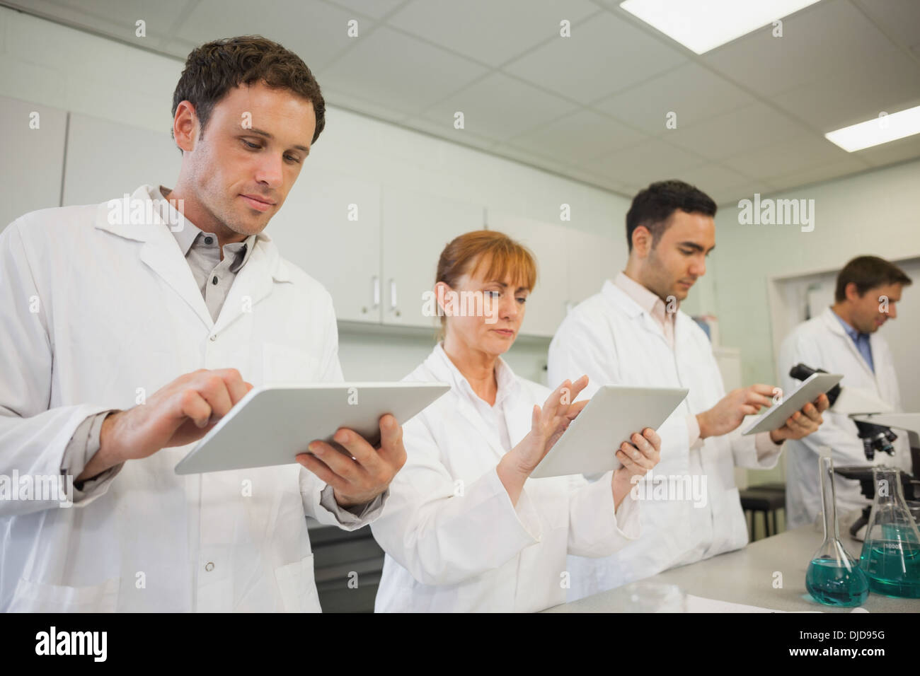 Row of scientists working with their tablets Stock Photo - Alamy