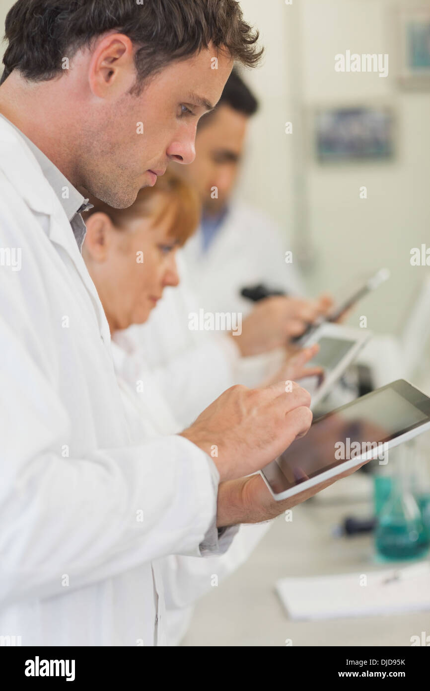 Profile view of some scientists working with their white tablets Stock ...