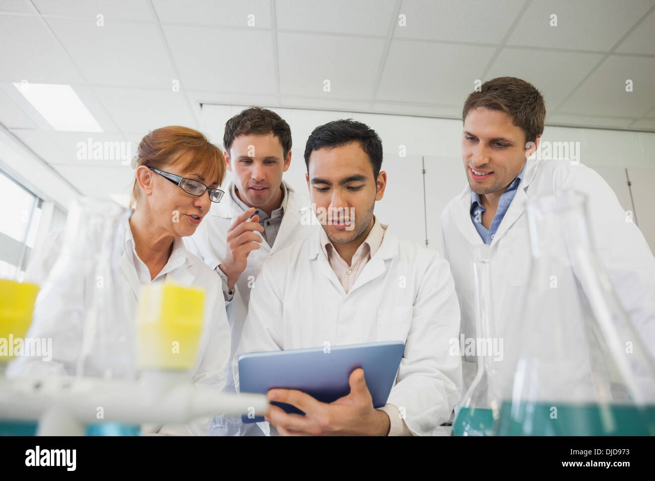 Low angle view of some scientists looking at a tablet Stock Photo - Alamy