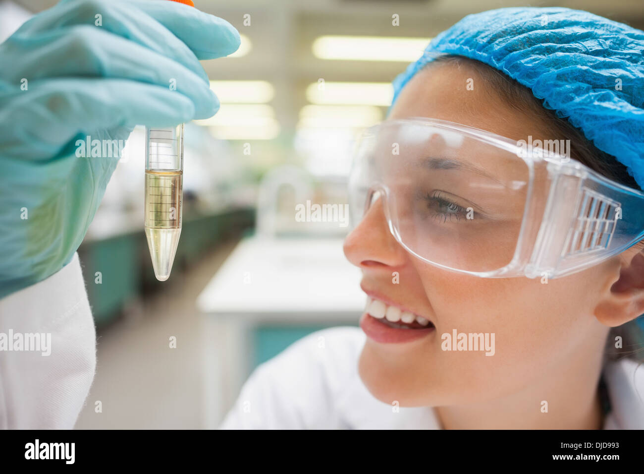 Smiling student looking closely at test tube Stock Photo - Alamy