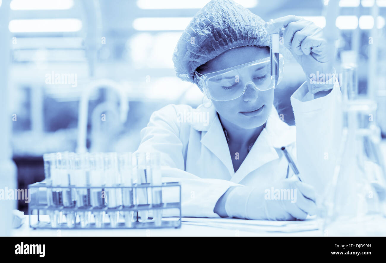Happy student holding test tube and taking notes Stock Photo - Alamy