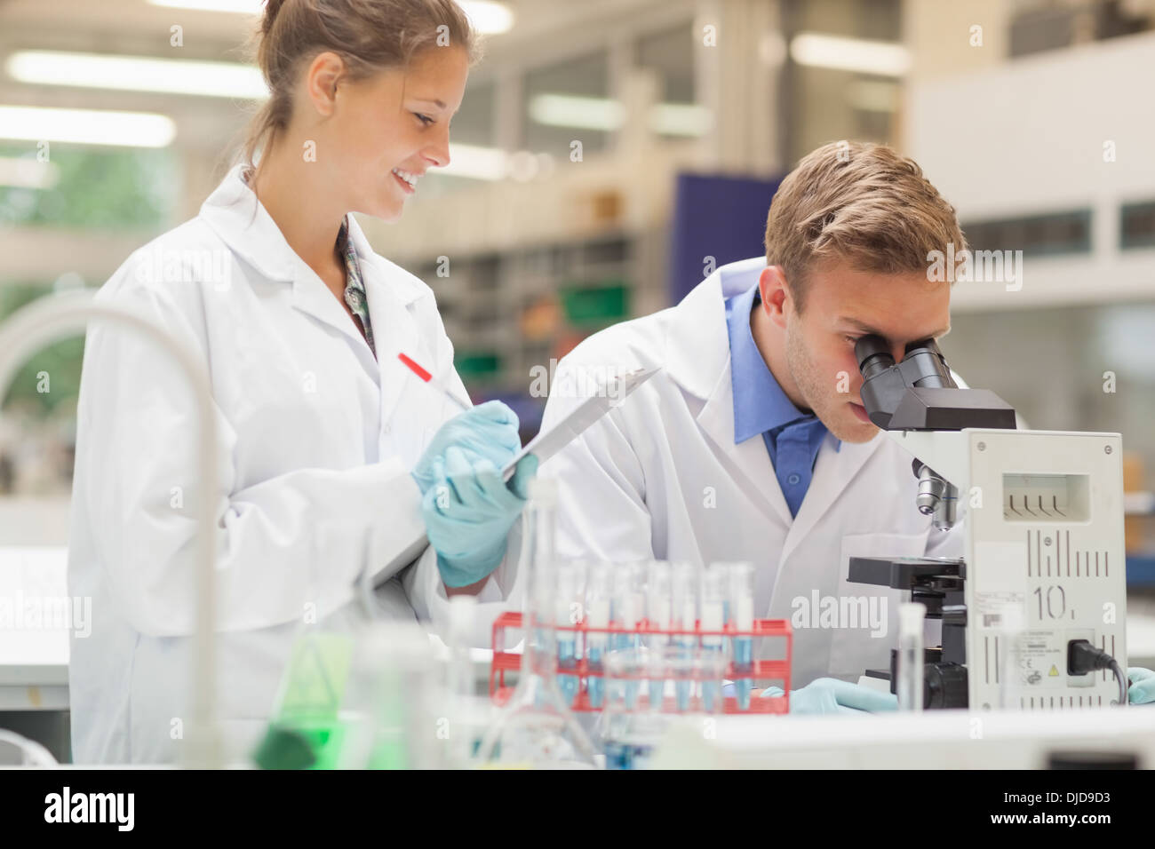 Classmates looking through microscope hi-res stock photography and ...