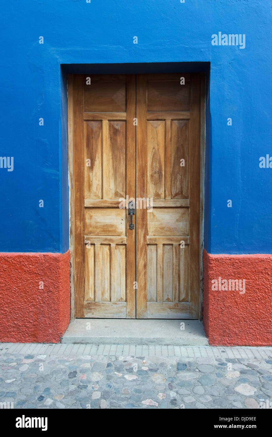 A Weathered Wooden Door Set Inside A Doorway Painted Blue And Red ...