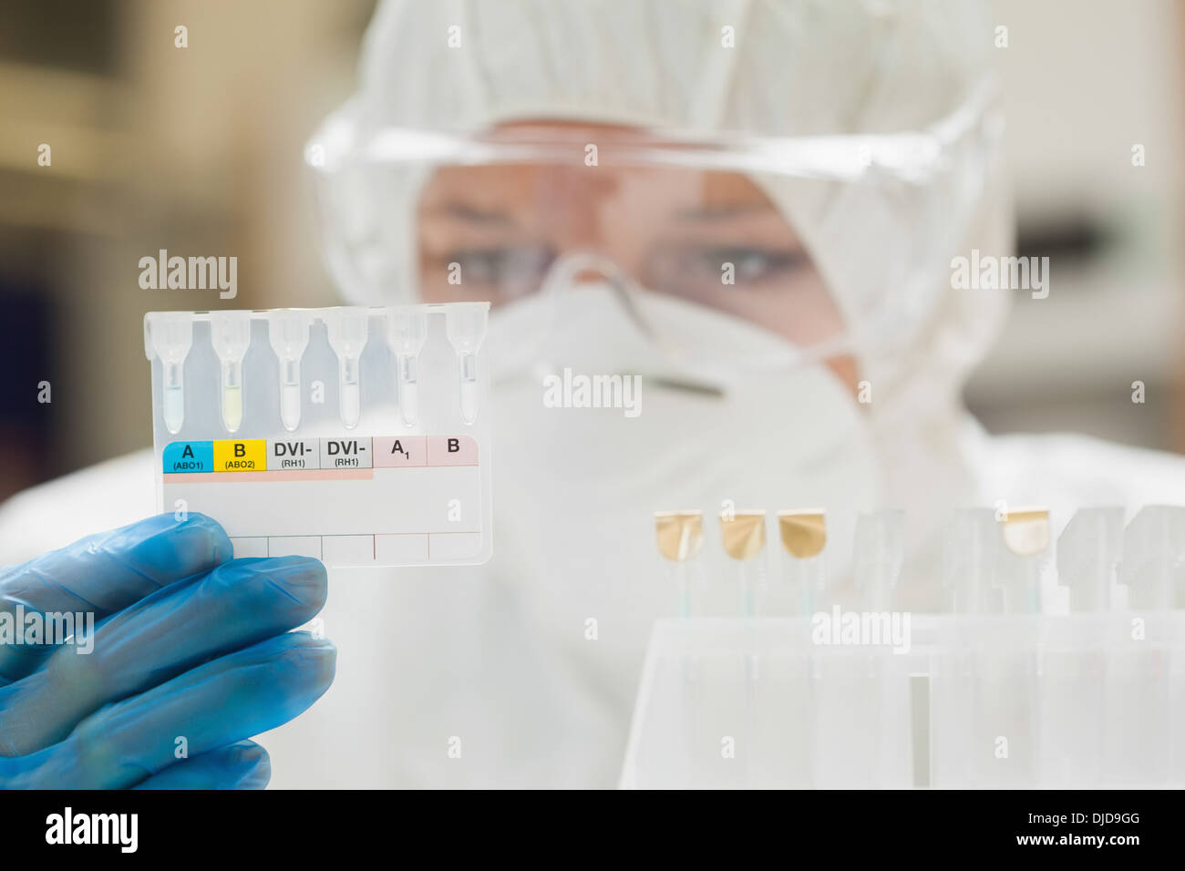 Lab assistant with mask looking at test results Stock Photo - Alamy