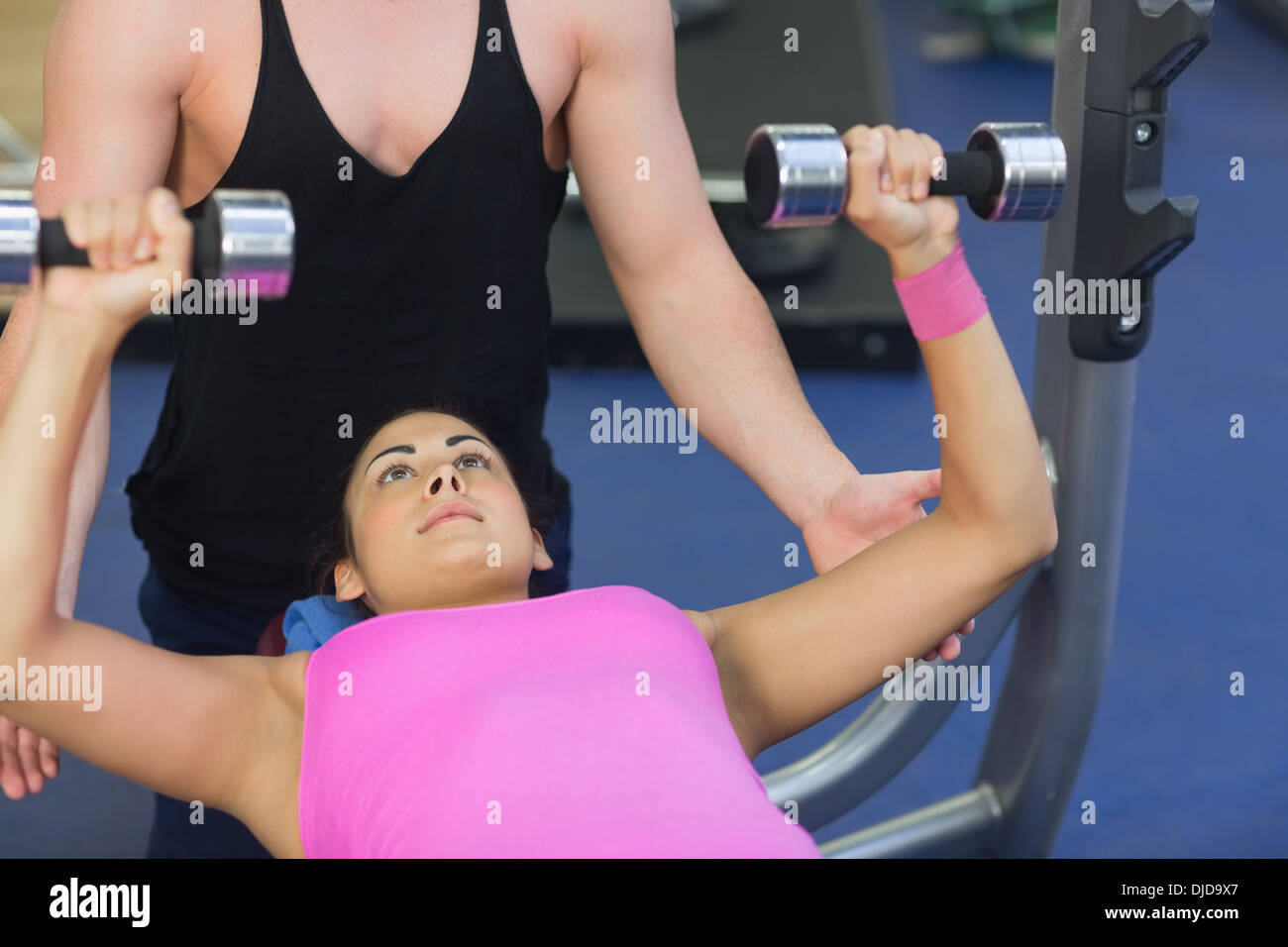 Instructor helping lying toned woman exercising with dumbbells Stock ...