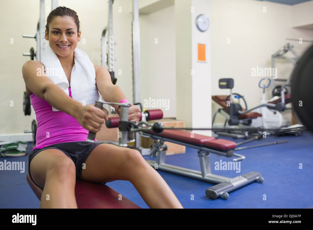 Smiling woman training arms on weight machine Stock Photo - Alamy