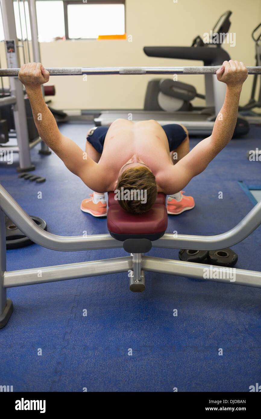 Muscular attractive man lifting barbell lying on bench Stock Photo - Alamy
