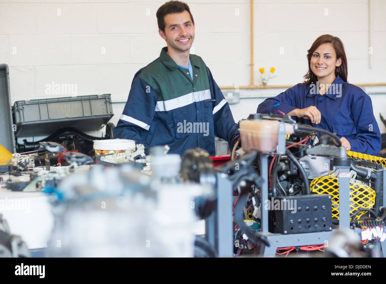 Happy instructor and trainee standing behind machine Stock Photo - Alamy