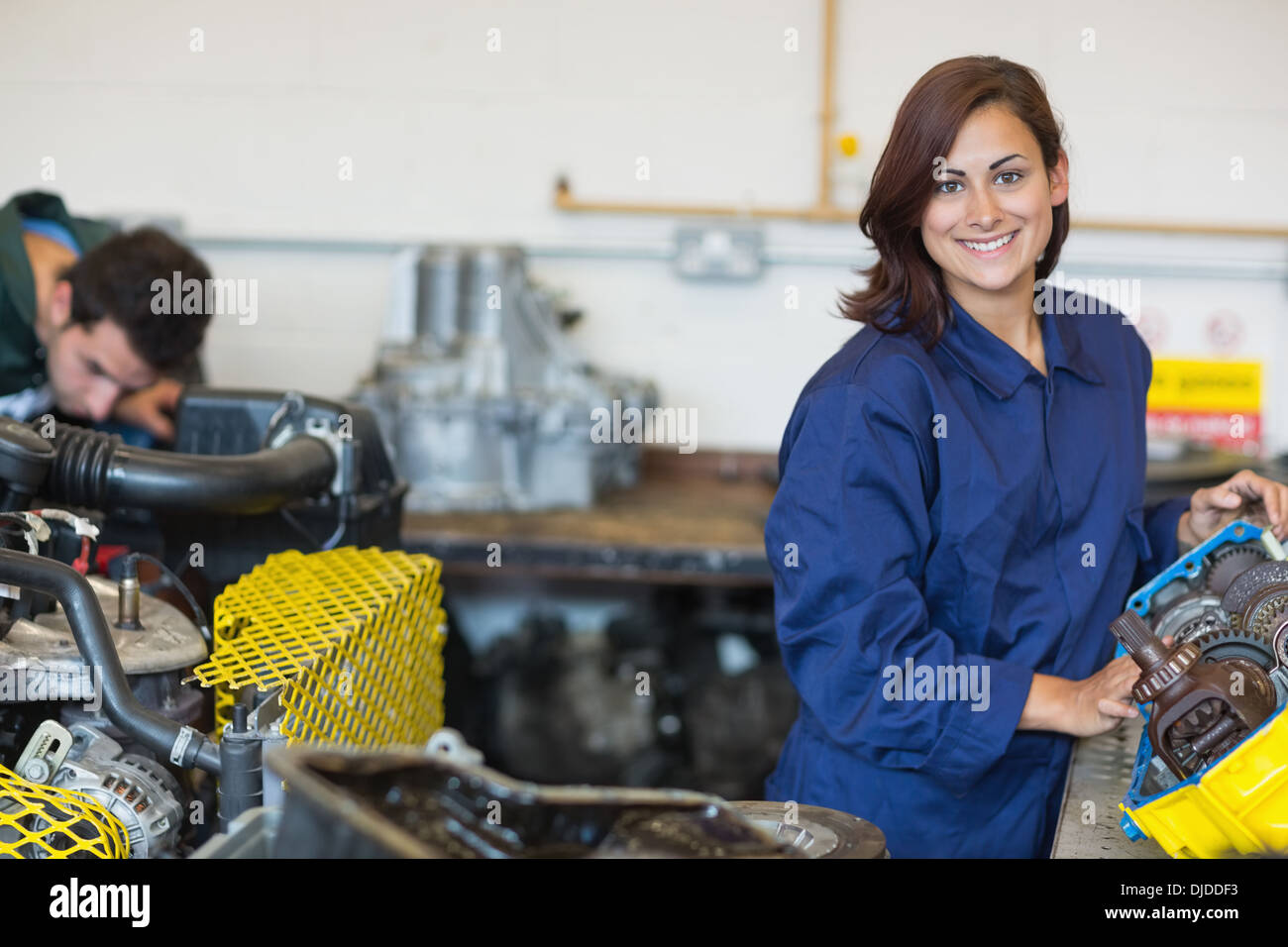 Smiling trainee repairing engine Stock Photo - Alamy