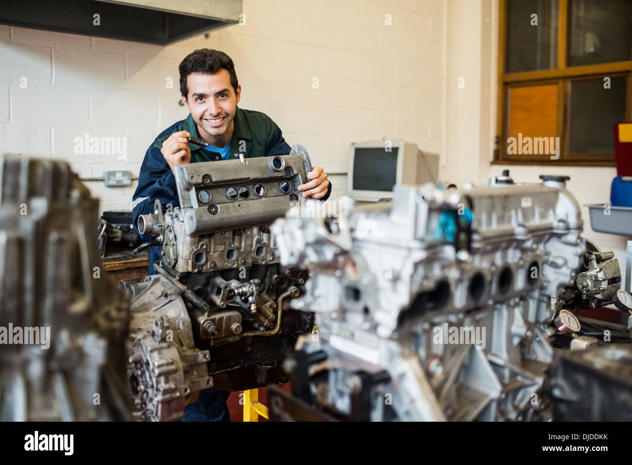 Happy repairman standing behind an engine Stock Photo - Alamy