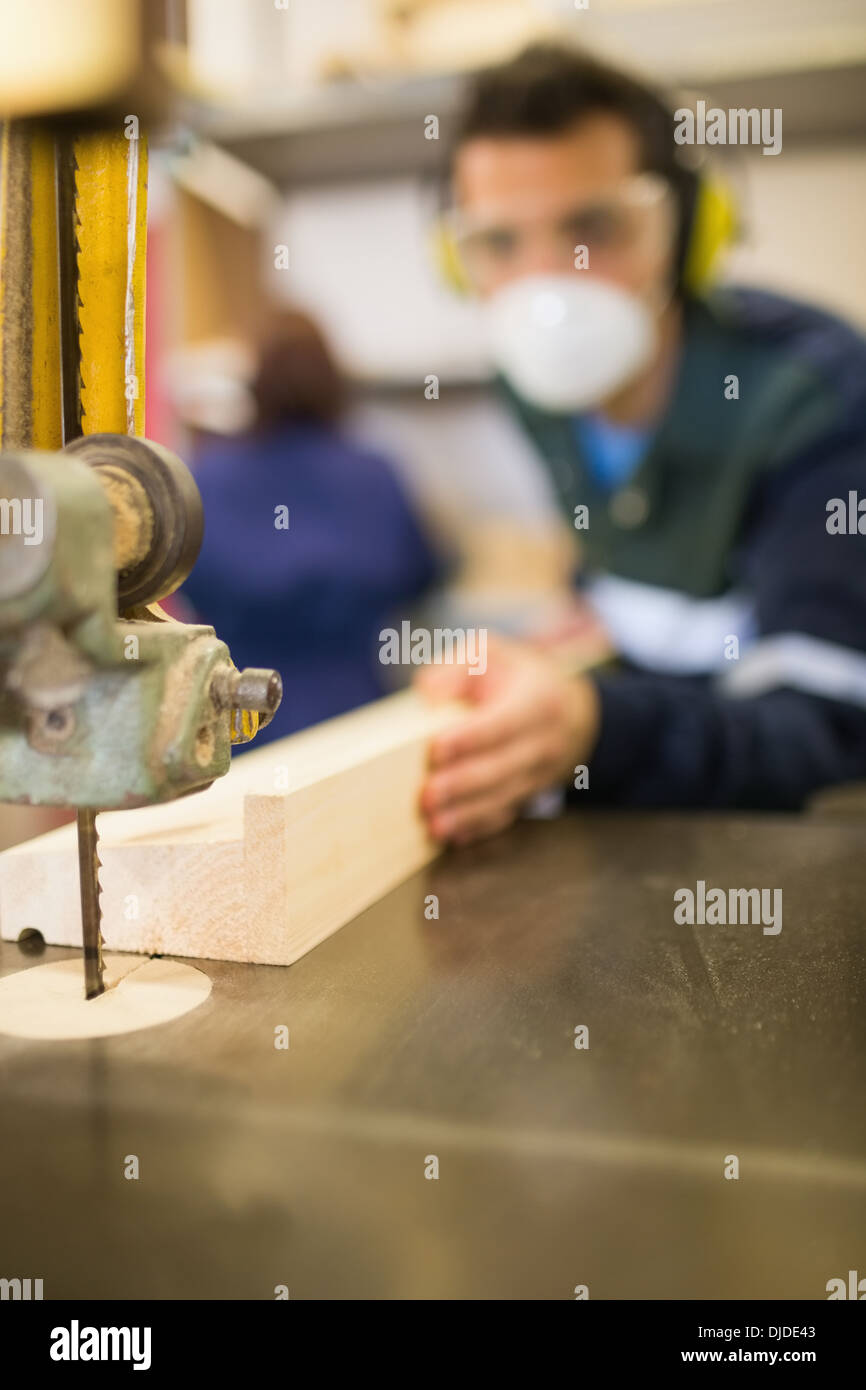 Carpenter wearing safety protection using a saw Stock Photo - Alamy