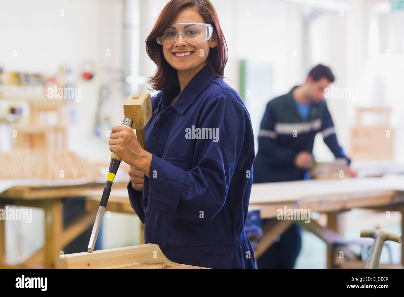 Smiling trainee using mallet and chisel Stock Photo - Alamy