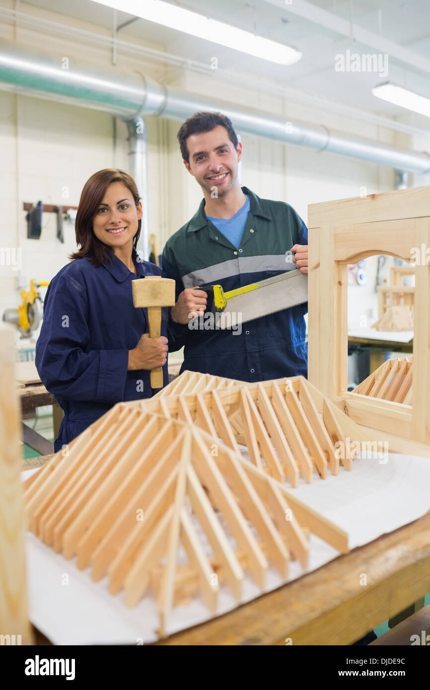Smiling trainee and instructor standing behind construction Stock Photo ...