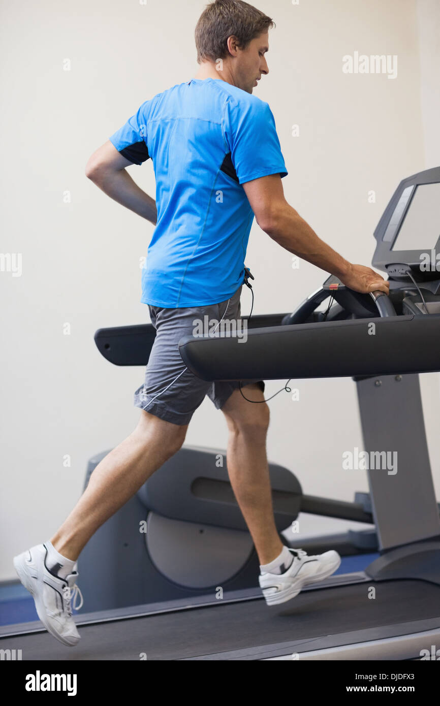 Healthy man running on treadmill at fitness studio Stock Photo - Alamy