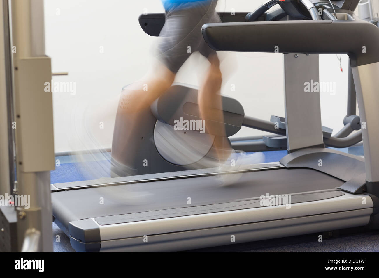 Low section side view of a healthy man running on treadmill Stock Photo ...