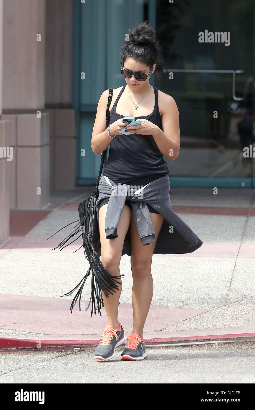 Vanessa Hudgens dialing a number on her cell phone as she leaves her ...