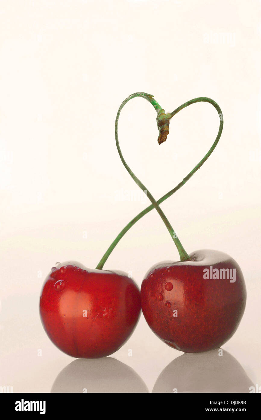 Two cherries, stems intersecting and forming a heart shape Stock Photo ...