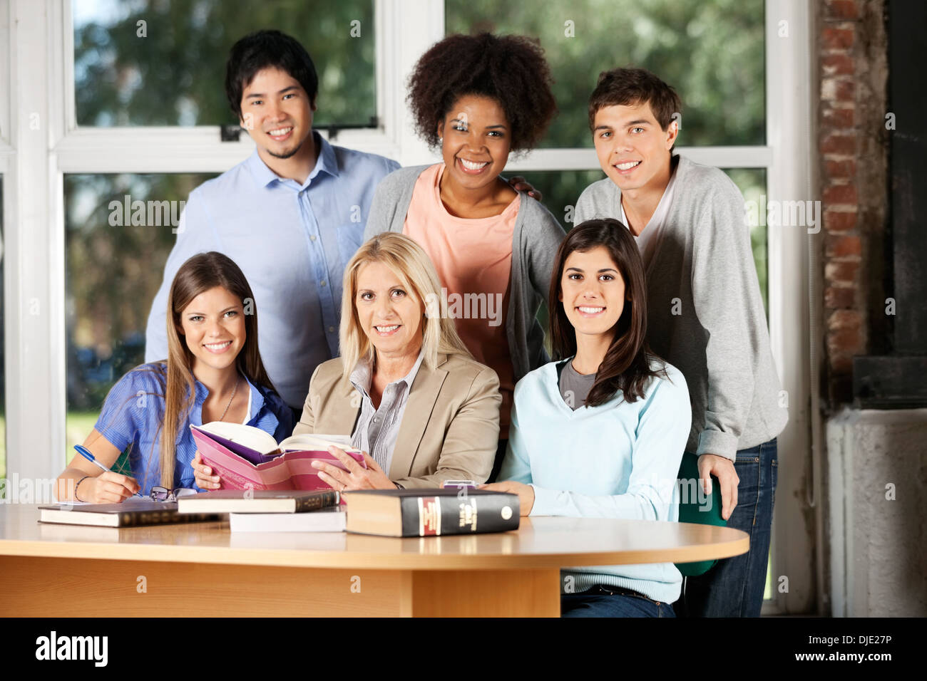 Students And Teacher With Books Smiling In Classroom Stock Photo - Alamy