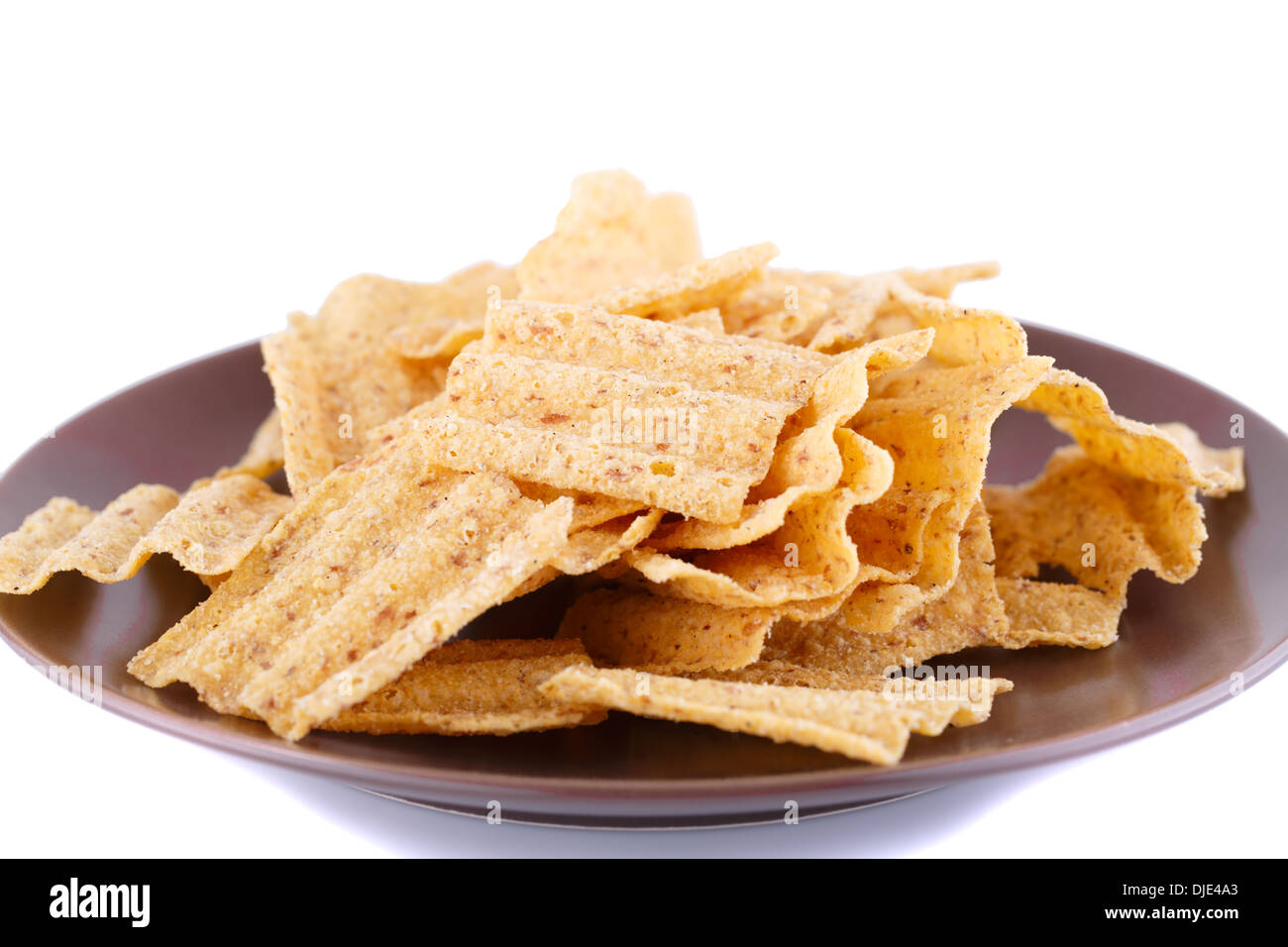 Wheat chips on plate isolated on white background Stock Photo - Alamy
