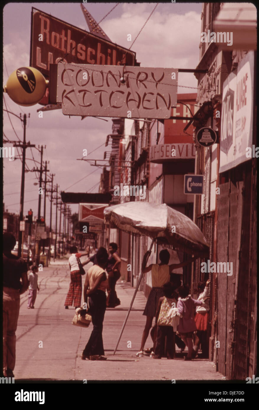 This photograph shows a street scene in the West Side of Chicago, an ...