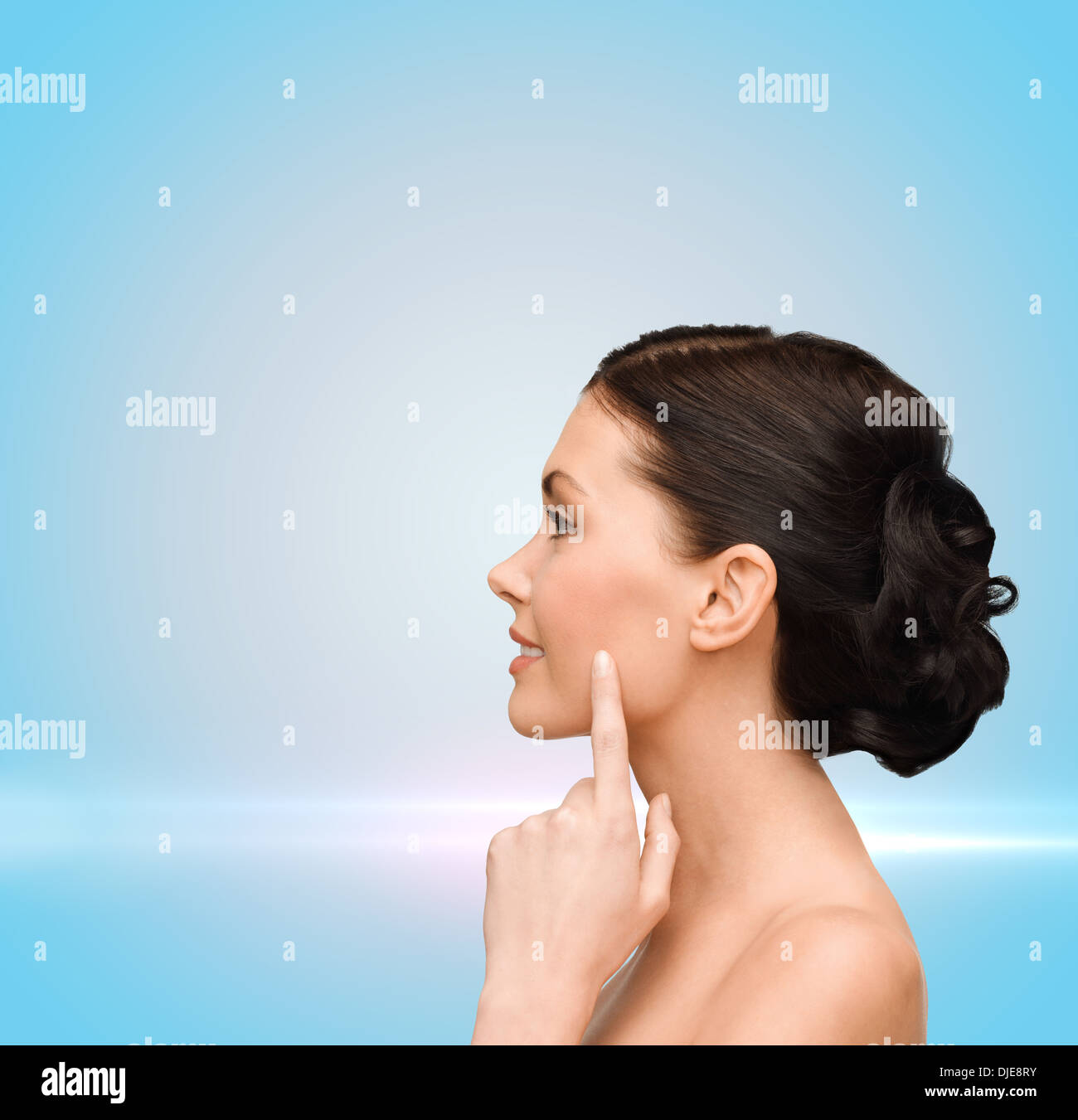 smiling young woman pointing to her cheek Stock Photo - Alamy