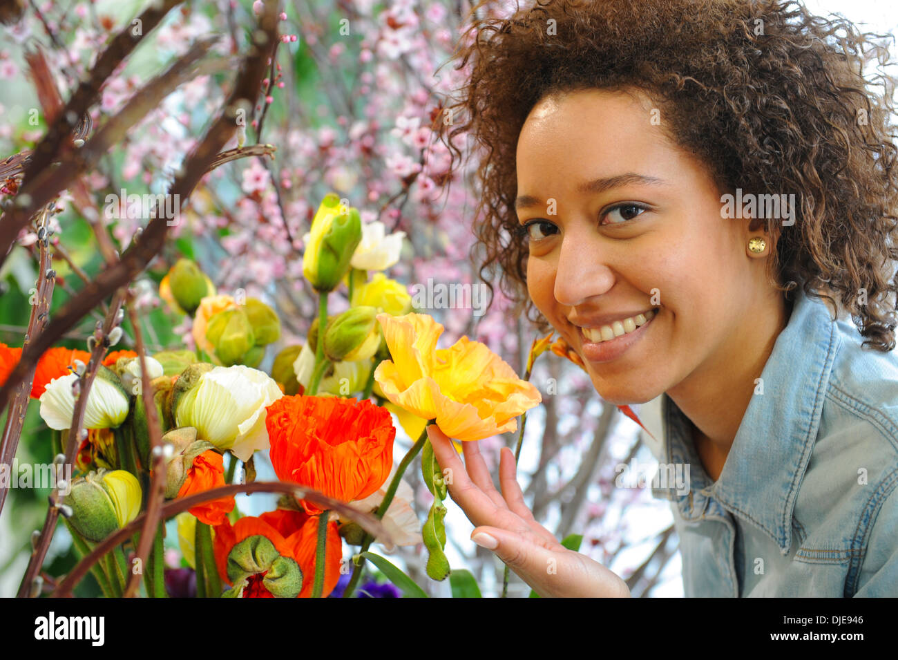 Consumerism: Woman smelling fresh flowers Stock Photo - Alamy
