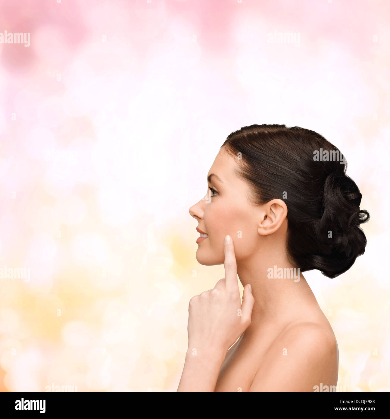 smiling young woman pointing to her cheek Stock Photo - Alamy