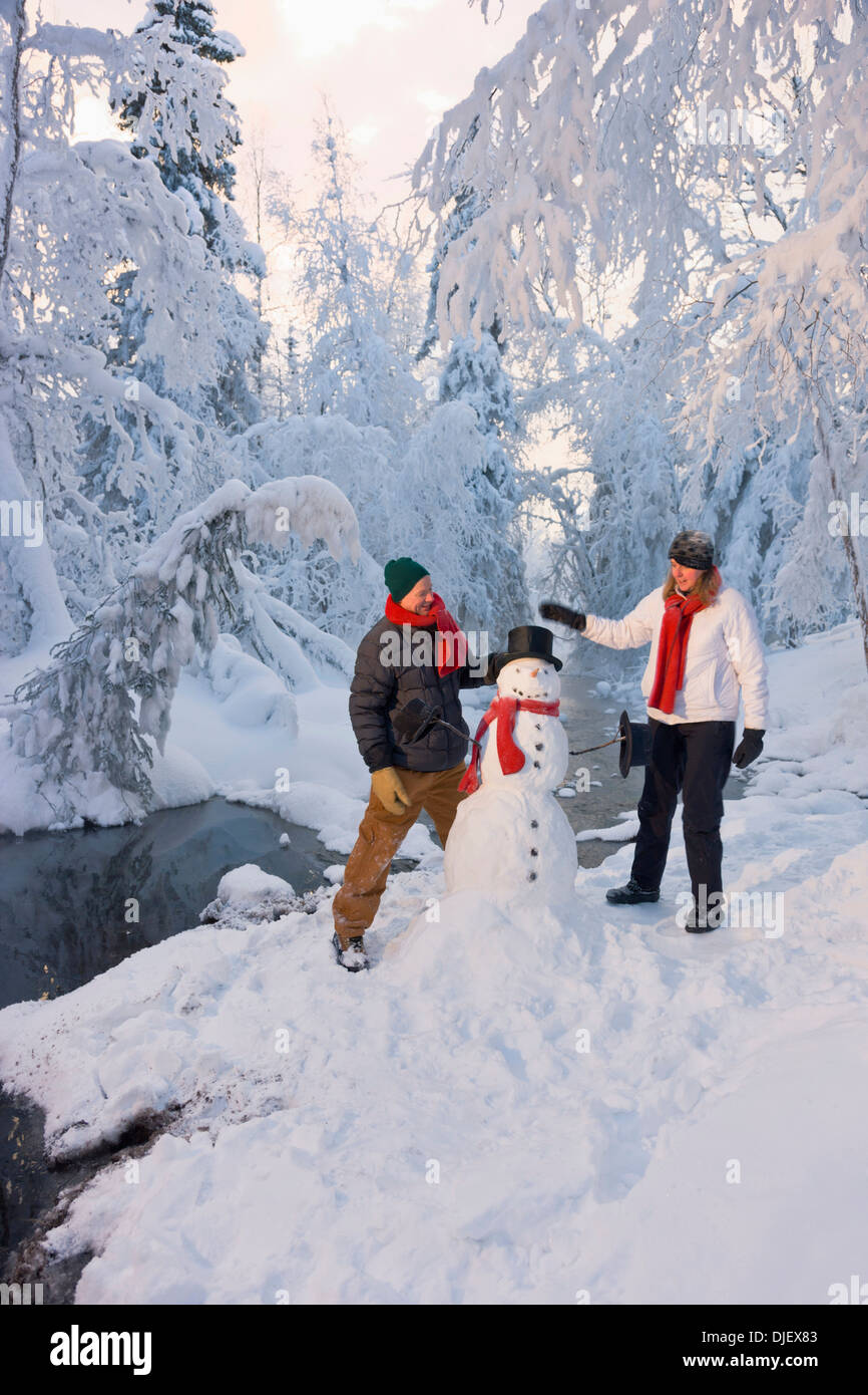 Family building snowman together in hi-res stock photography and images ...