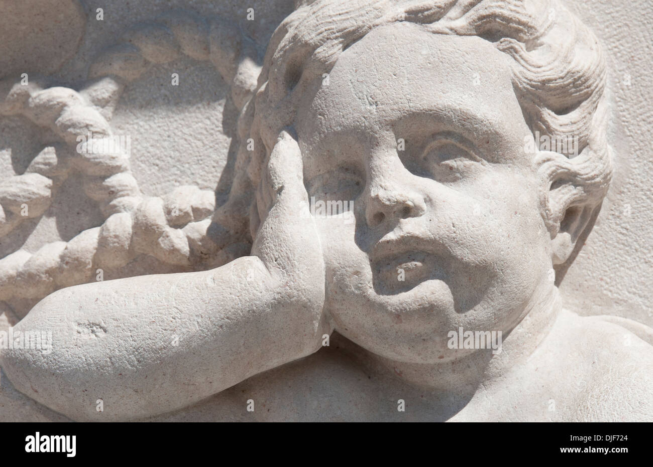 Carving of cherub looking bored Stock Photo - Alamy