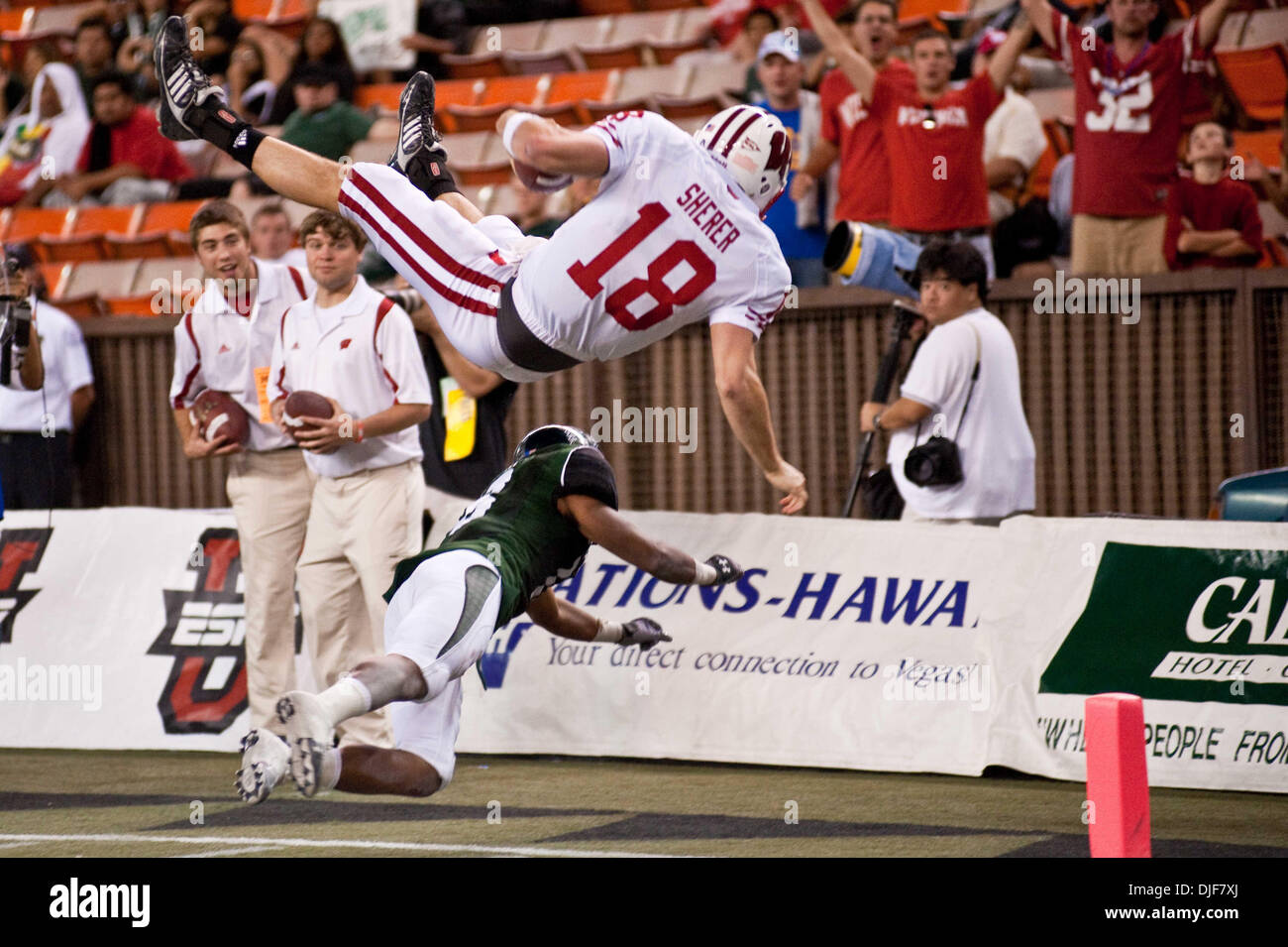 Wisconsin quarterback Dustin Sherer #18 leaps over a Hawaii defender to ...