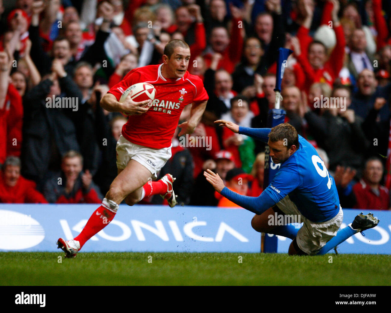 Shane Williams of Wales races clear of Simon Picone of Italy to score a ...