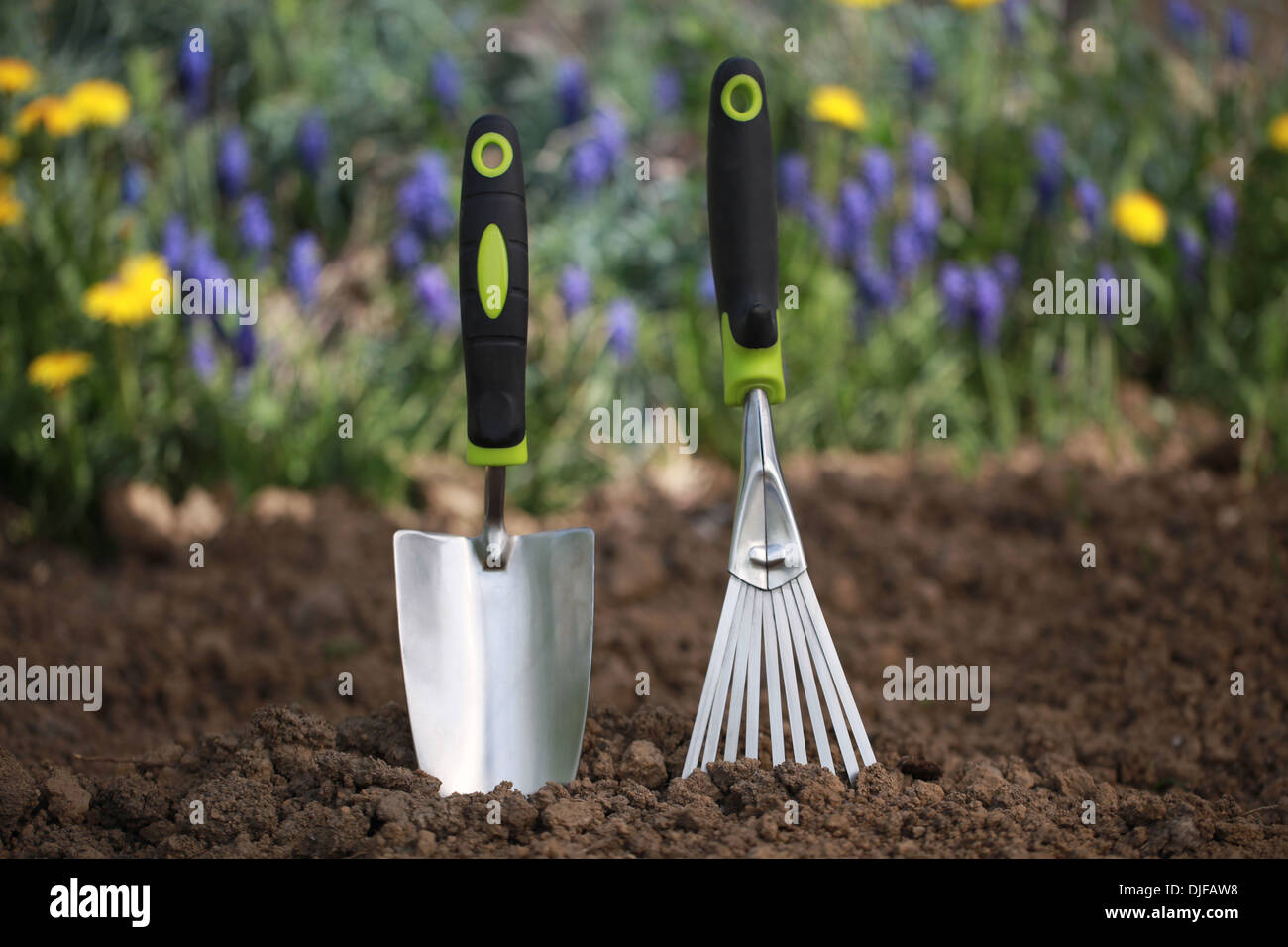 Garden tools like a hand trowel and a rake in garden soil Stock Photo ...