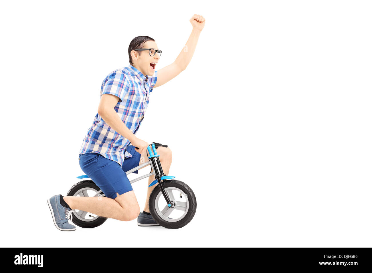 Excited guy riding a small bicycle and gesturing happiness Stock Photo ...