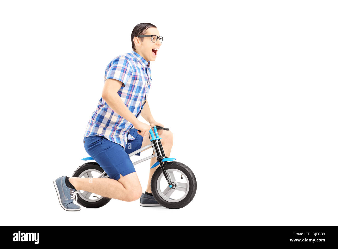 Excited guy riding a small bicycle Stock Photo - Alamy