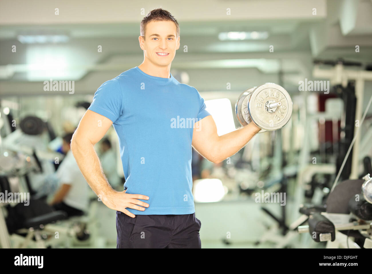 Smiling muscular man lifting weight Stock Photo - Alamy