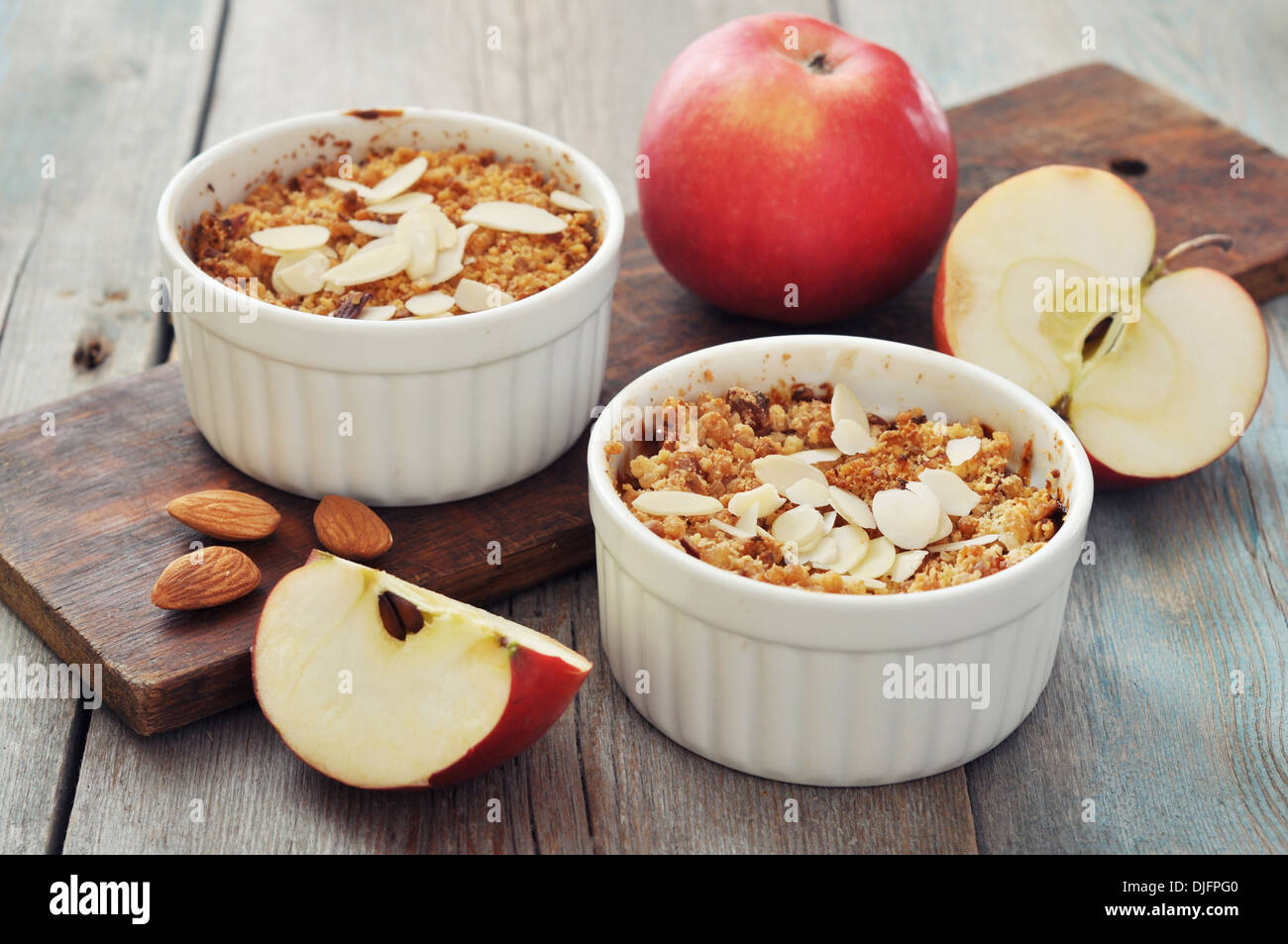 Apple crumble in ceramic molds with fresh apples on wooden background ...