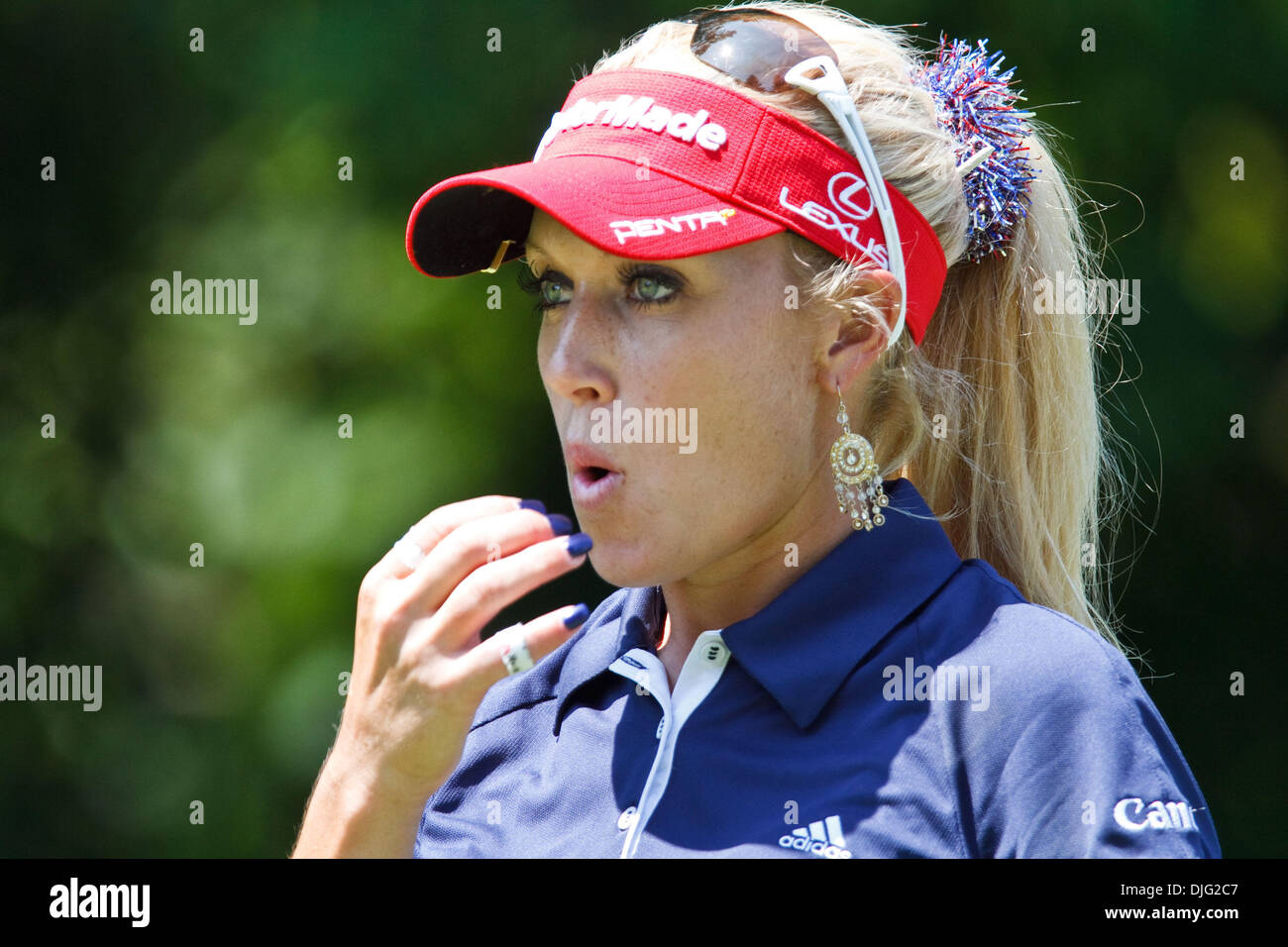 Natalie Gulbis tries to dry her hand as she watchers her tee shot ...