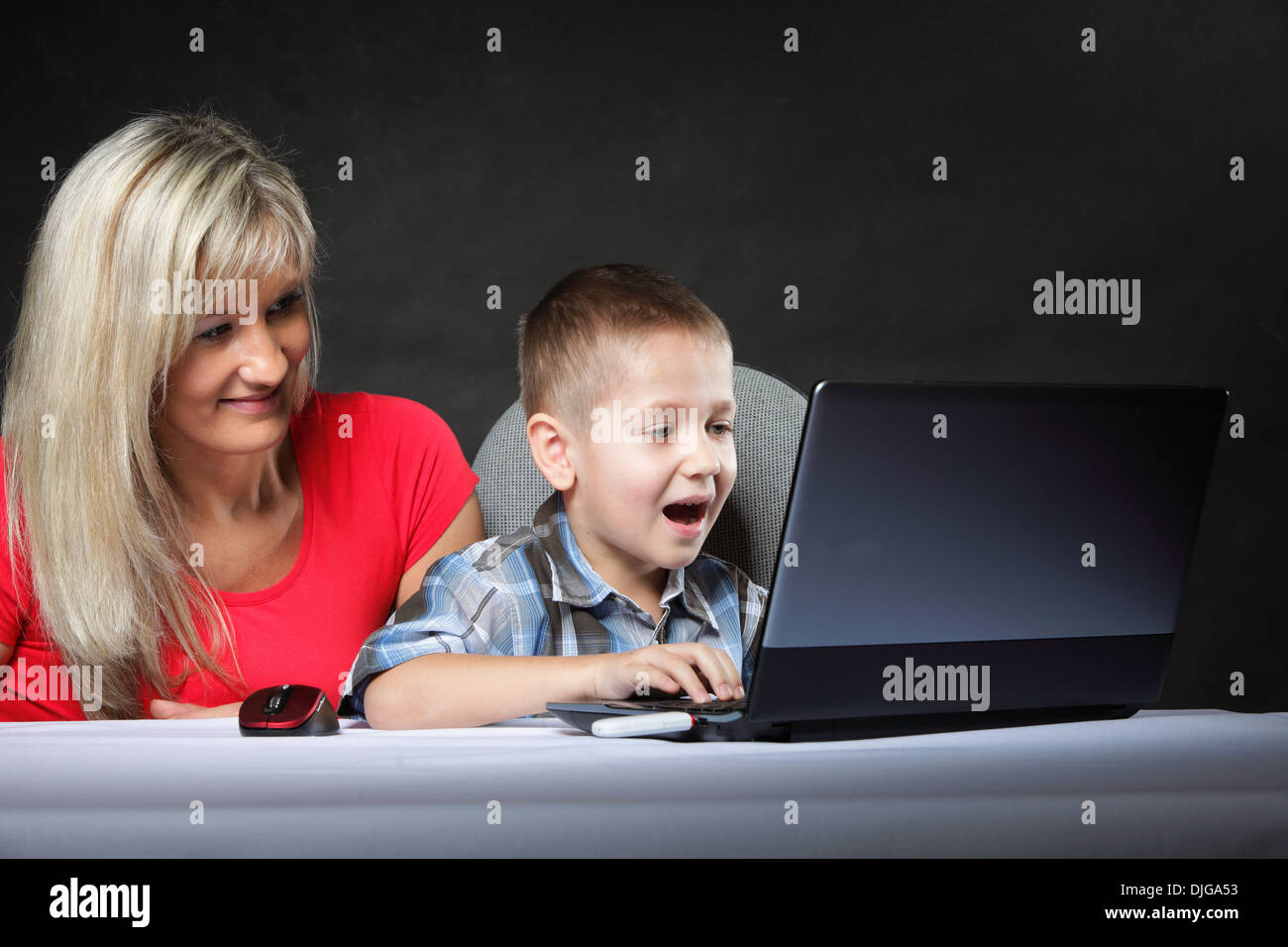 mother with son together looking on the laptop computer black ...