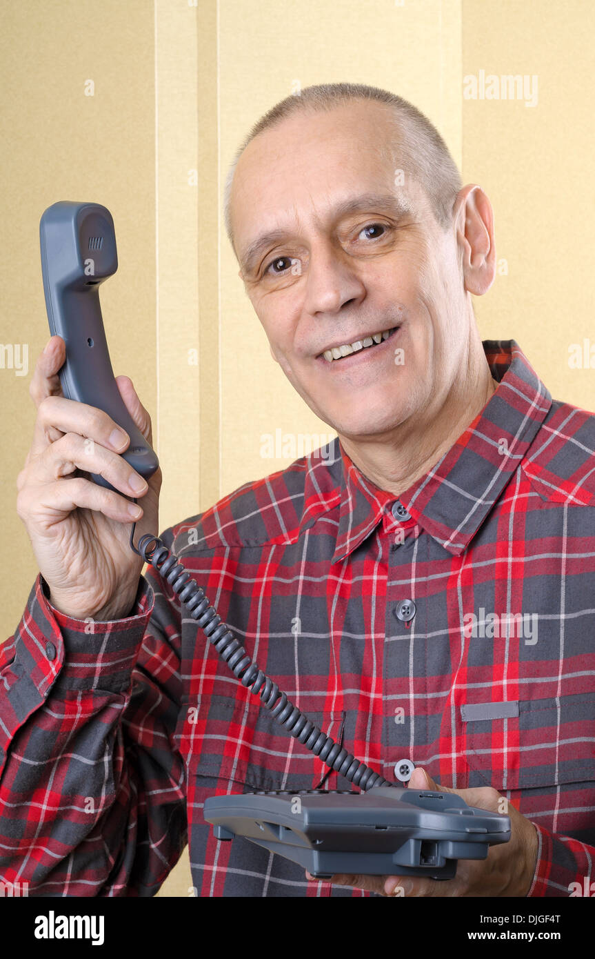 A senior man giving the phone handset to somebody else - There is a ...