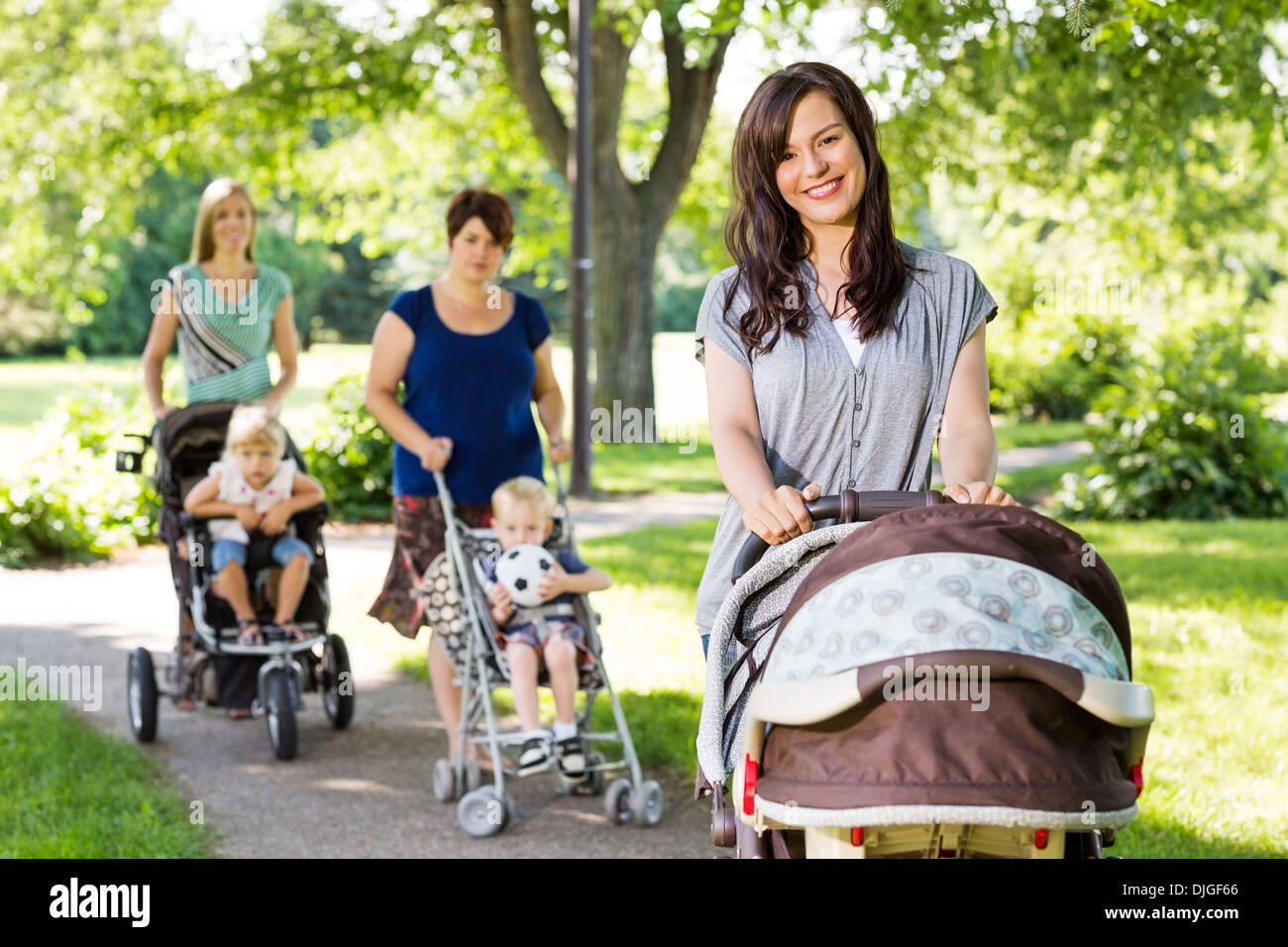 Beautiful Mother Pushing Baby Stroller In Park Stock Photo - Alamy