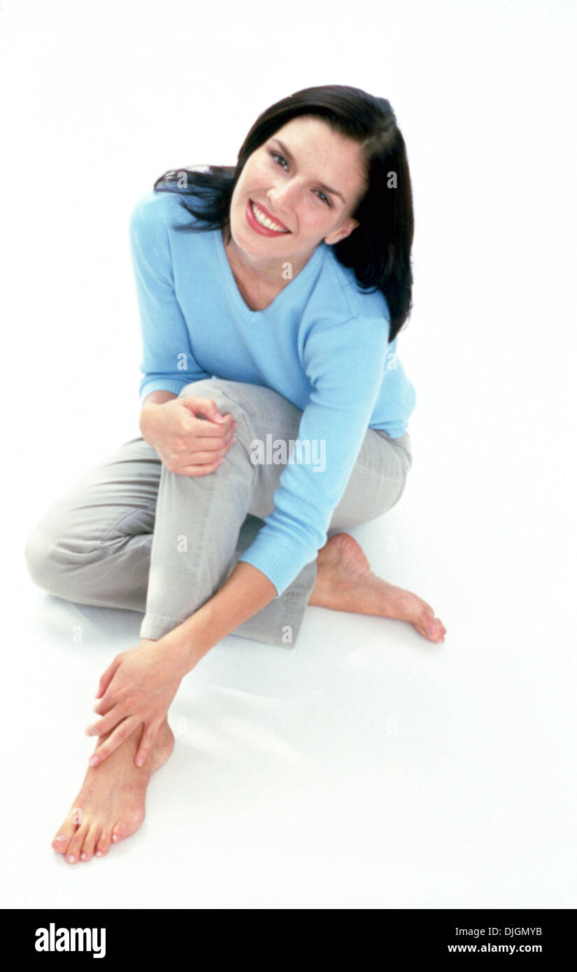 Woman smiling legs crossed Stock Photo - Alamy